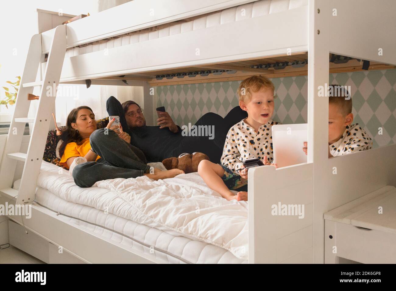 Parents with sons on bed Stock Photo - Alamy