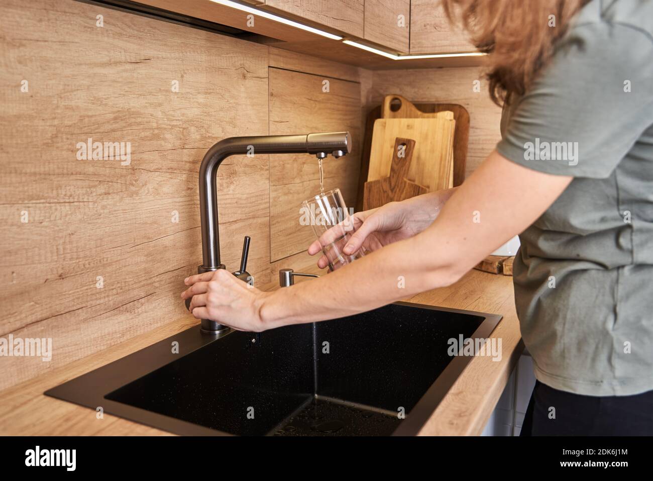 Woman pouring clean water from tap filter into a glass Stock Photo - Alamy