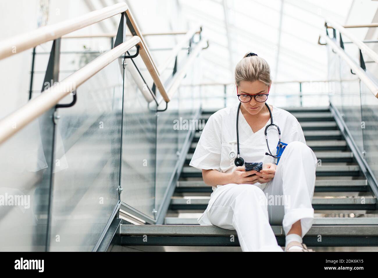 Female doctor sitting on stairs Stock Photo - Alamy
