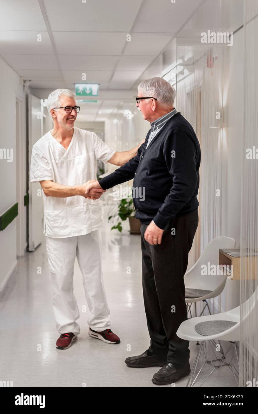Doctor giving patient handshake Stock Photo - Alamy