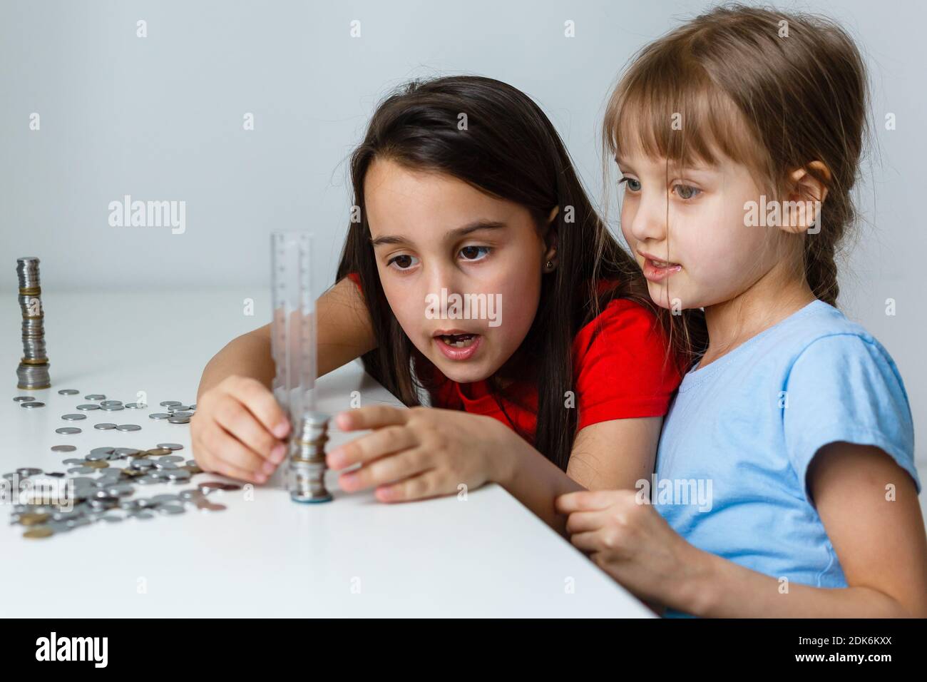 Two kids counting coins together Stock Photo - Alamy