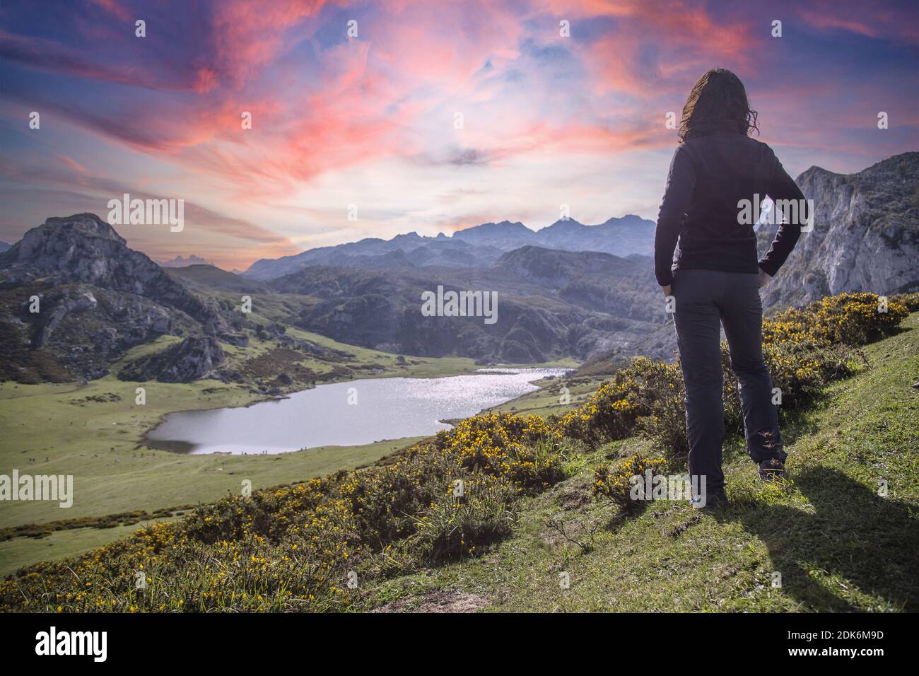 A back view of a young adventurous female looking at the Lake Ercina ...