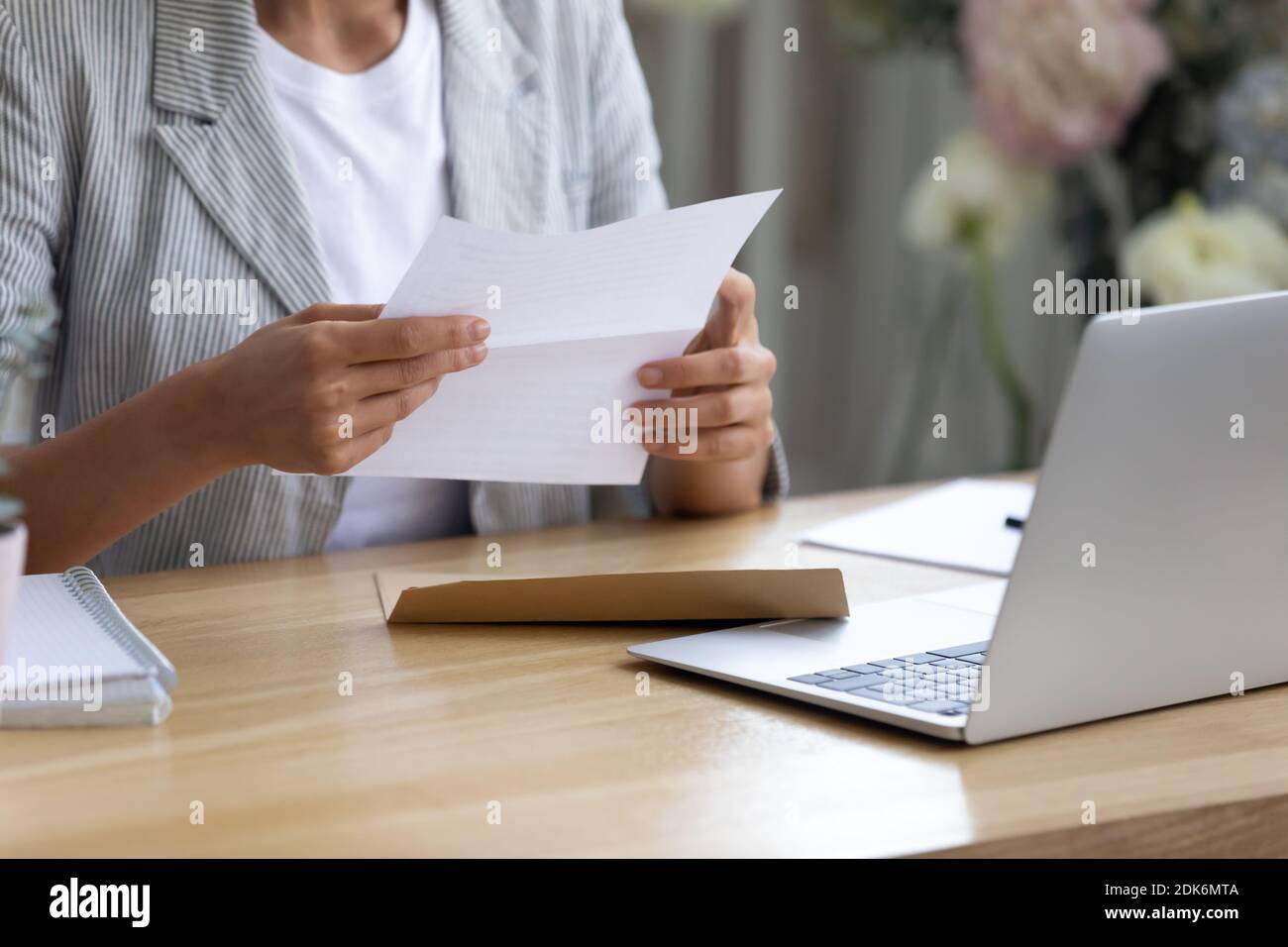 Young woman holding letter in hands reading information from bank Stock ...