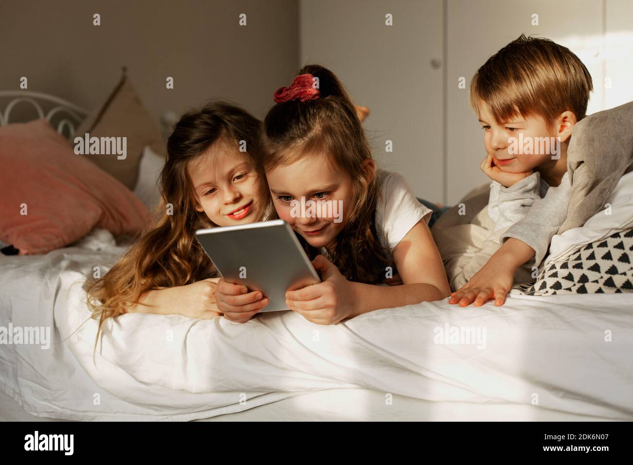 Teenage using tablet computer lying on bed hi-res stock photography and ...