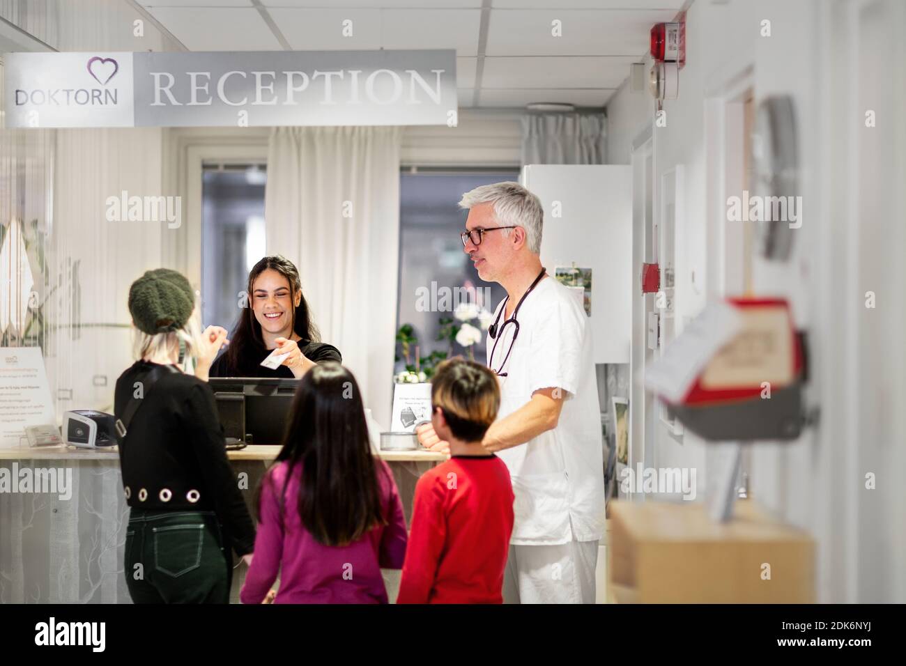 People at reception in doctor's surgery Stock Photo - Alamy