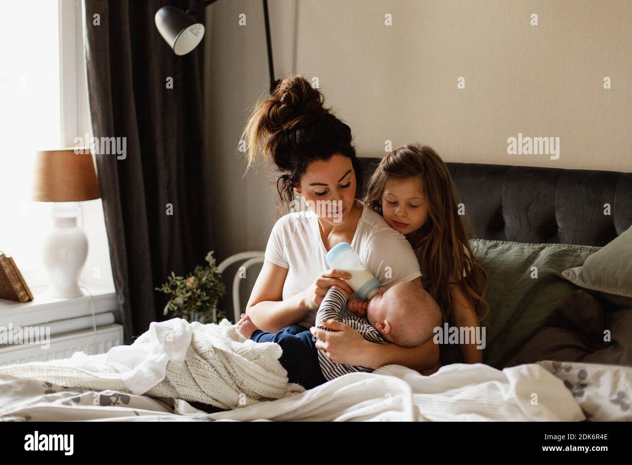 Mother feeding baby on bed Stock Photo - Alamy