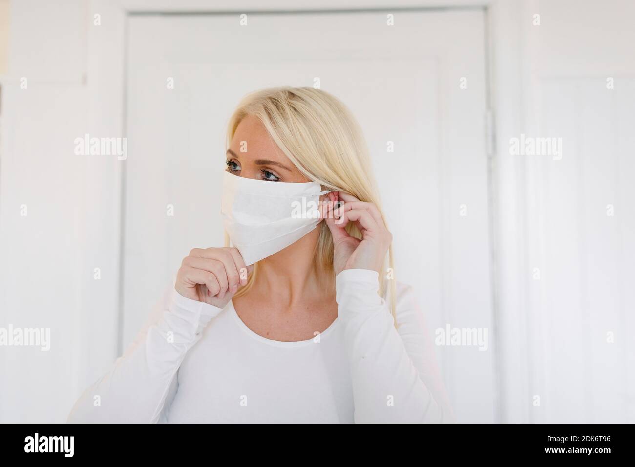 Woman putting on face mask hi-res stock photography and images - Alamy