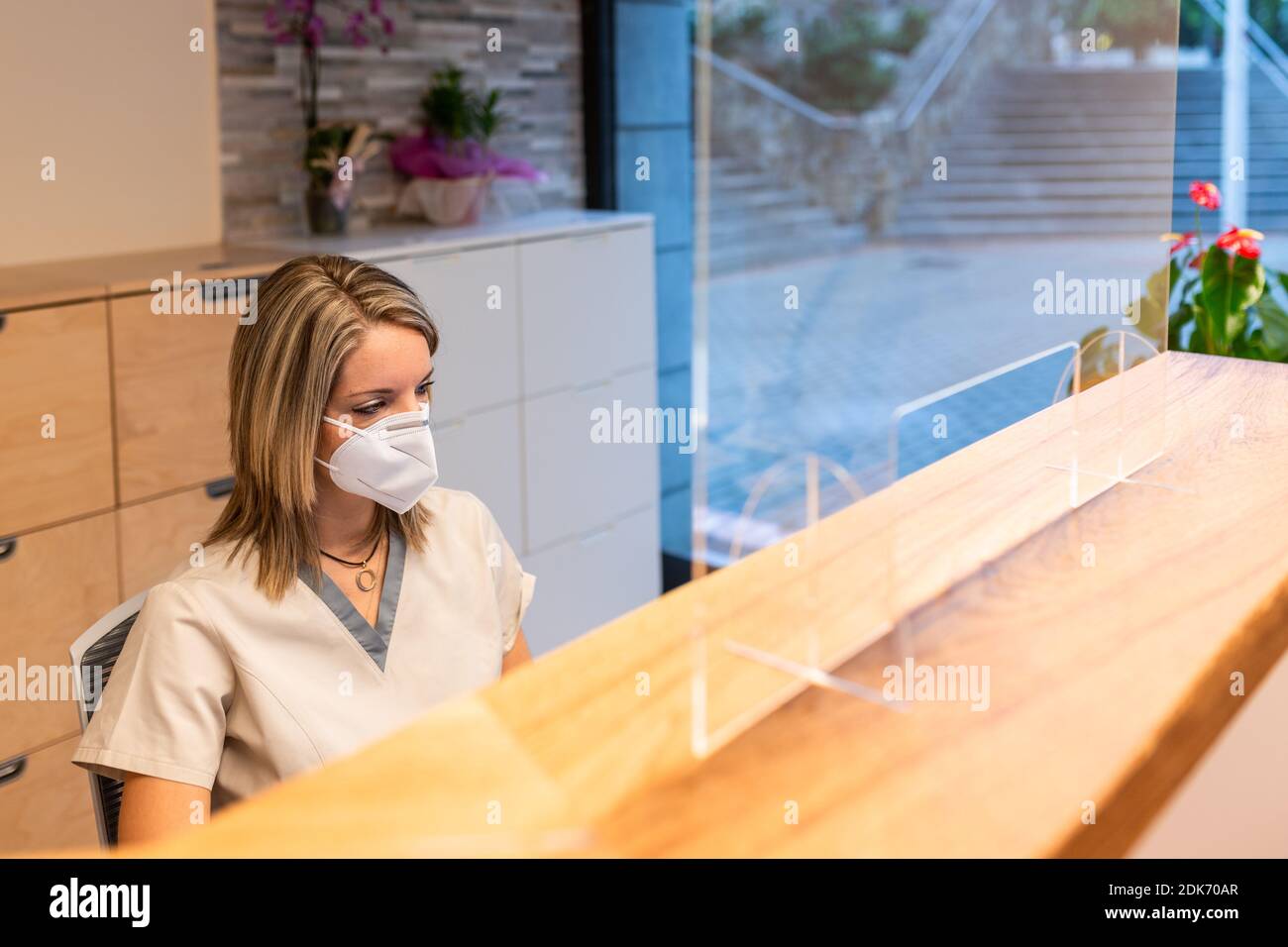 female receptionist from a physiotherapy center behind a reception desk ...