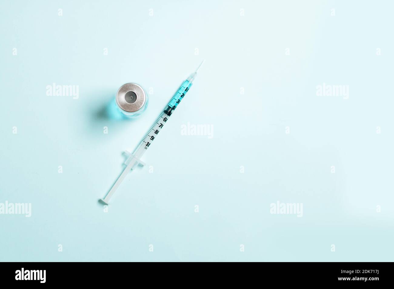 Syringes with blue medicine liquid on an isolated blue solid background ...