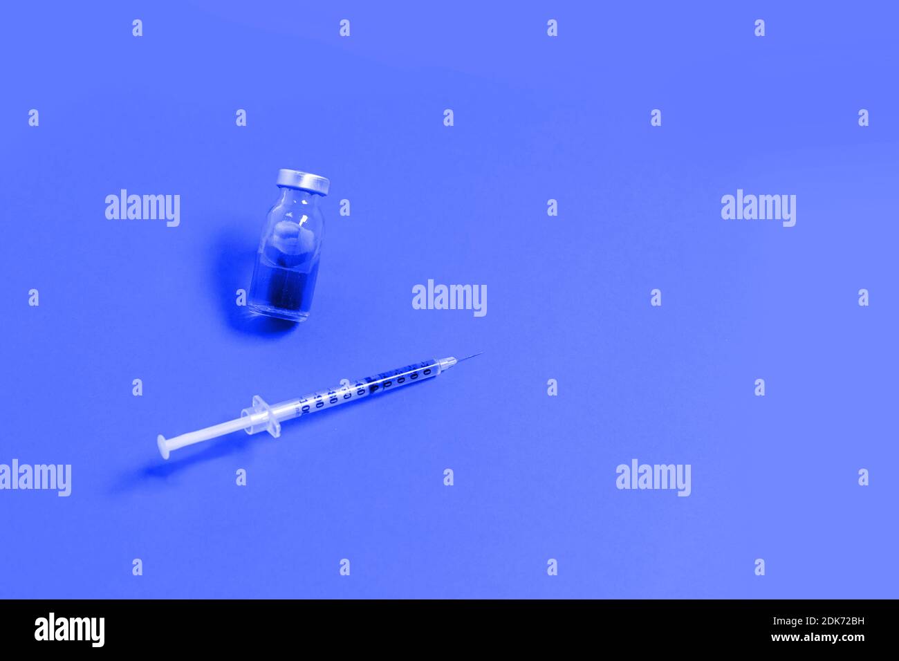 Syringe with blue medicine liquid on blue background. Vaccination ...
