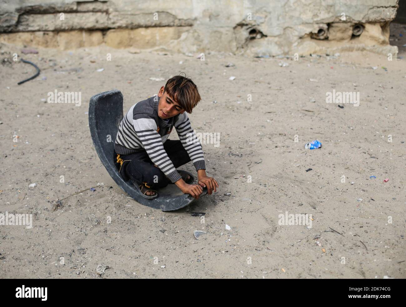 Gaza, Palestine. 14th Dec, 2020. A Palestinian boy plays outside their ...