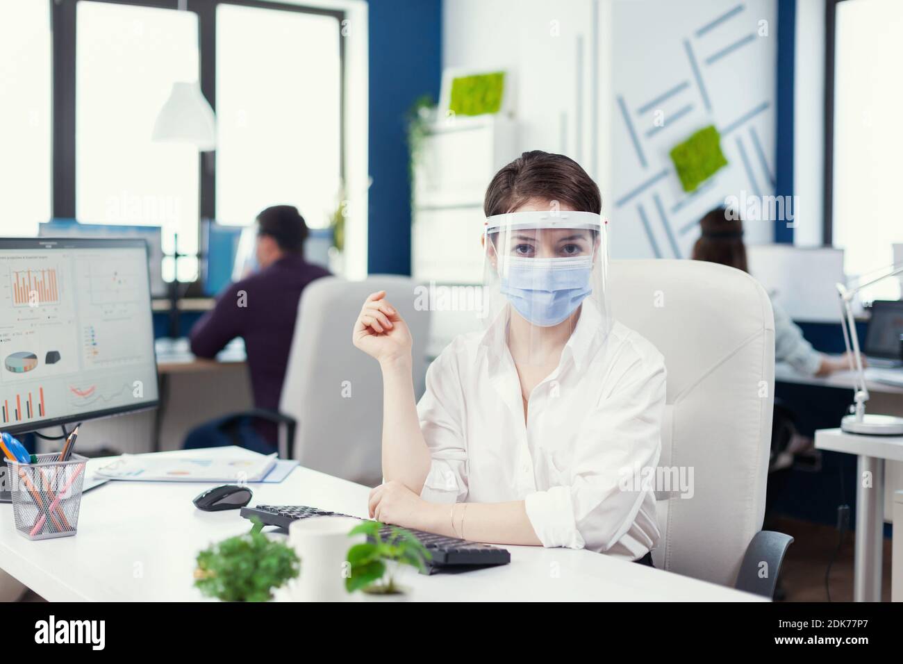 Portrait of office worker wearing a face shield. Business team working ...