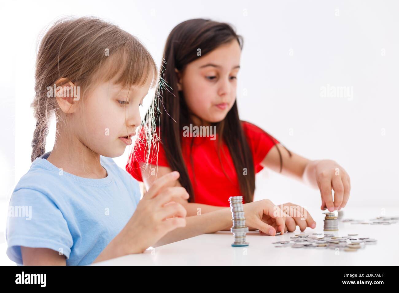 Two kids counting coins together Stock Photo - Alamy
