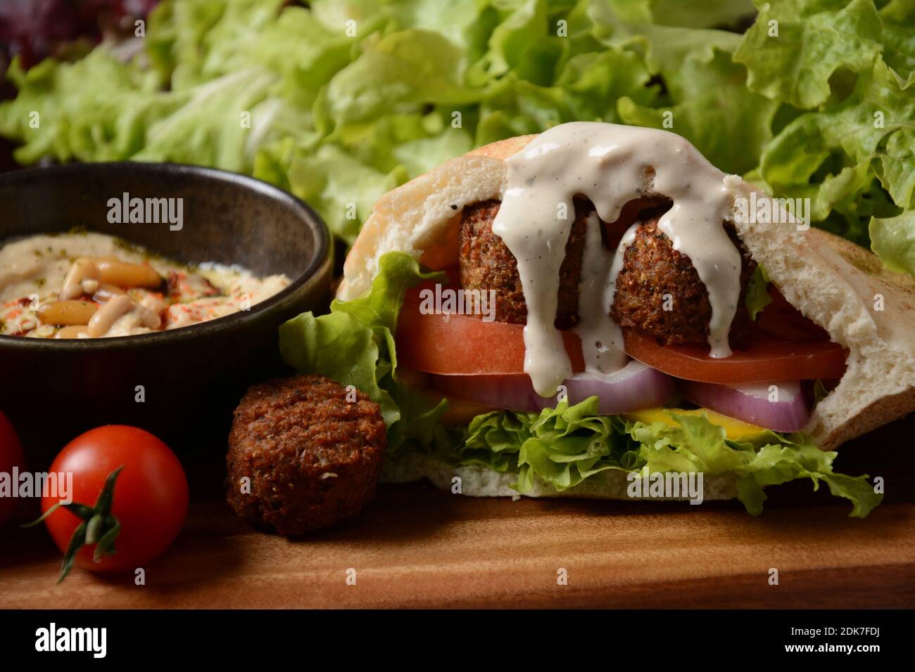 Falafel in pita bread with vegetable salad, harissa sauce, humus ...