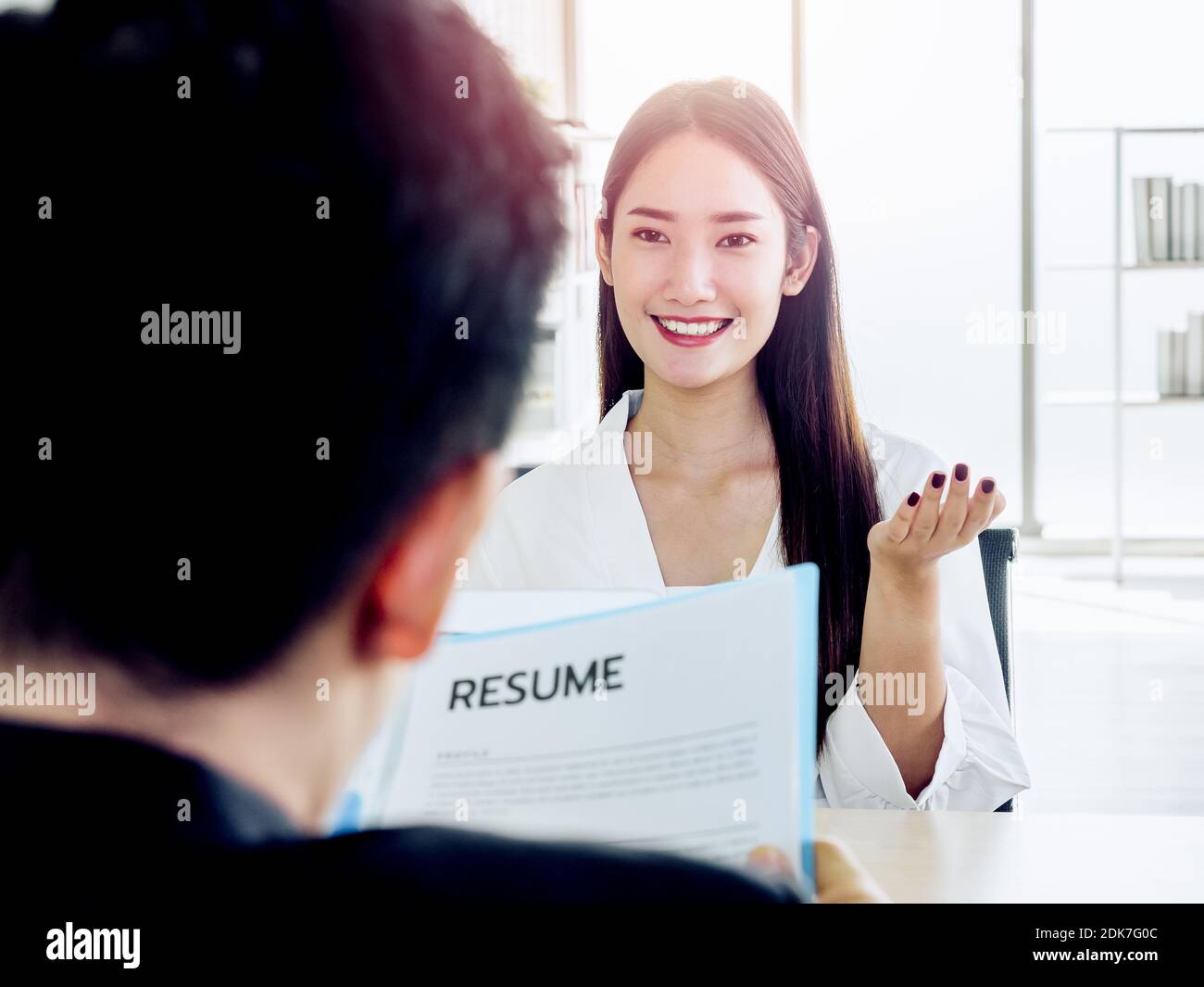 Young attractive Asian woman during job interview with businessman in ...