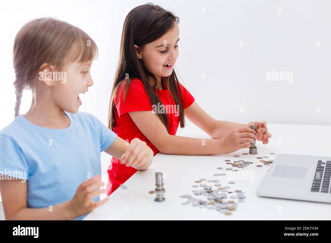 Two kids counting coins together Stock Photo - Alamy