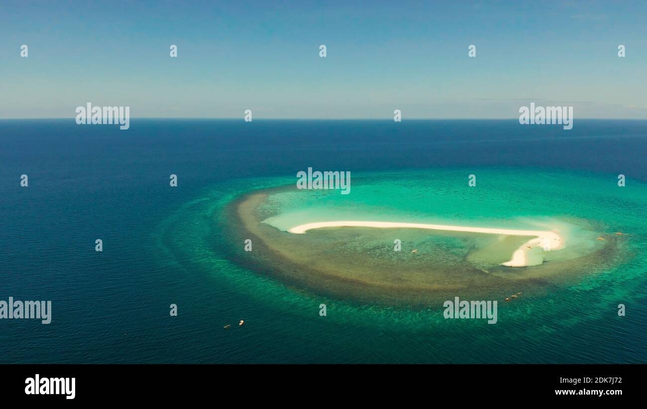 Tropical white island and sandy beach with tourists surrounded by coral ...