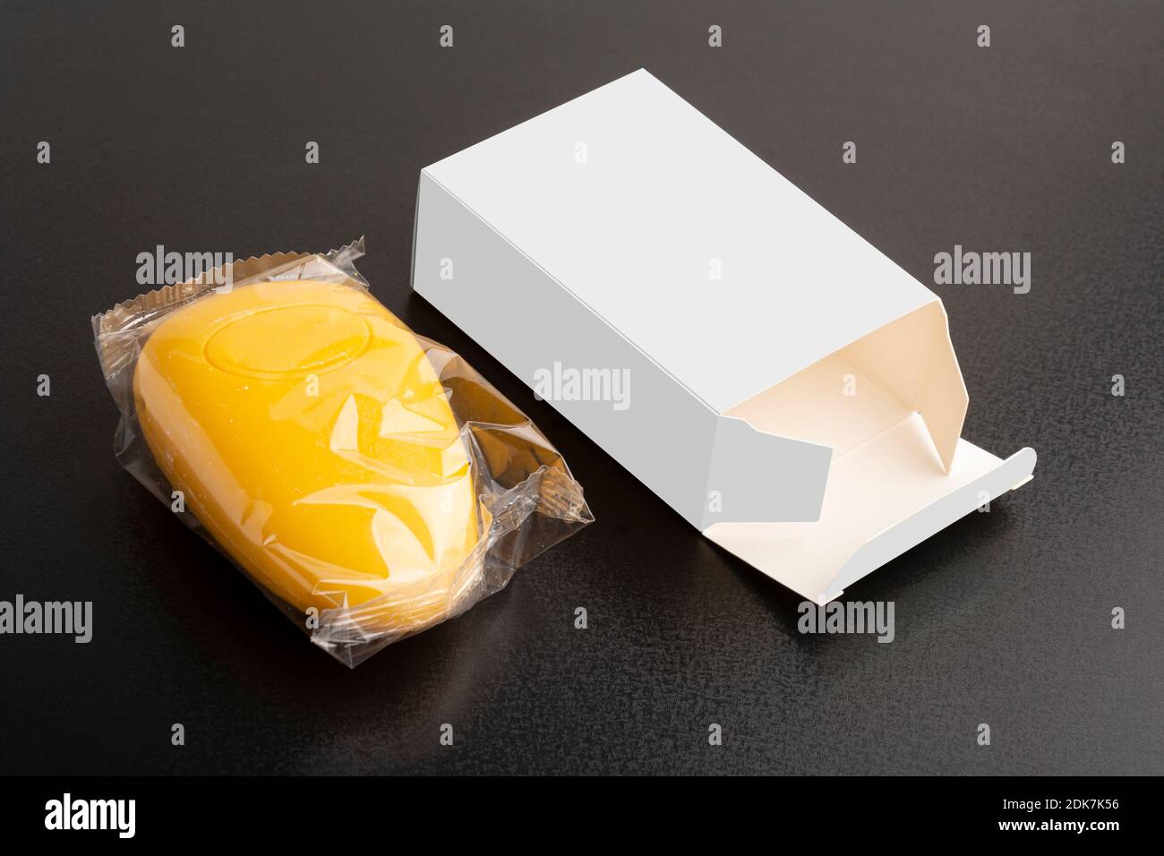 Opened yellow soap package on black surface, editable mock-up series ...
