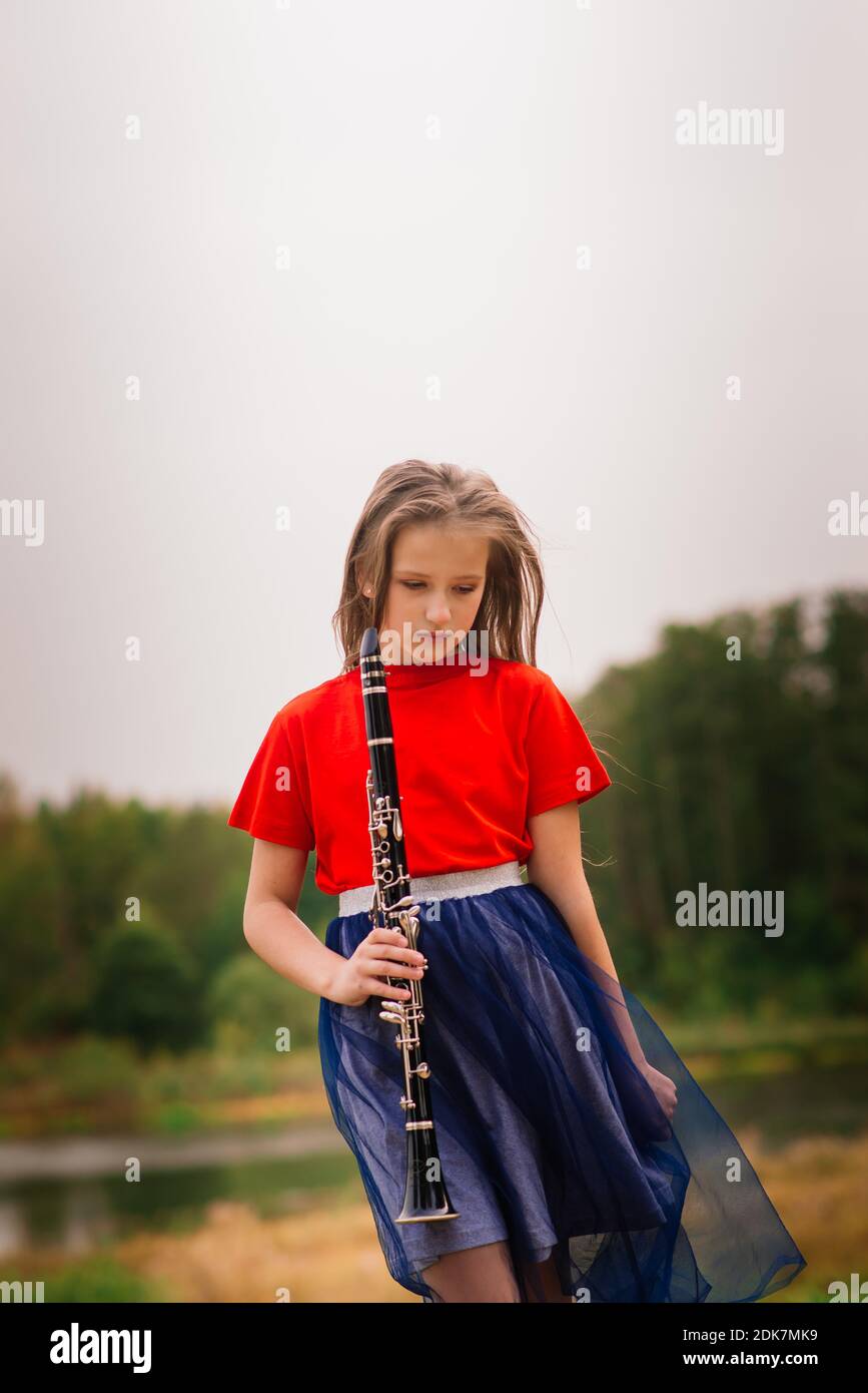 Young attractive girl playing clarinet in fall park Stock Photo - Alamy