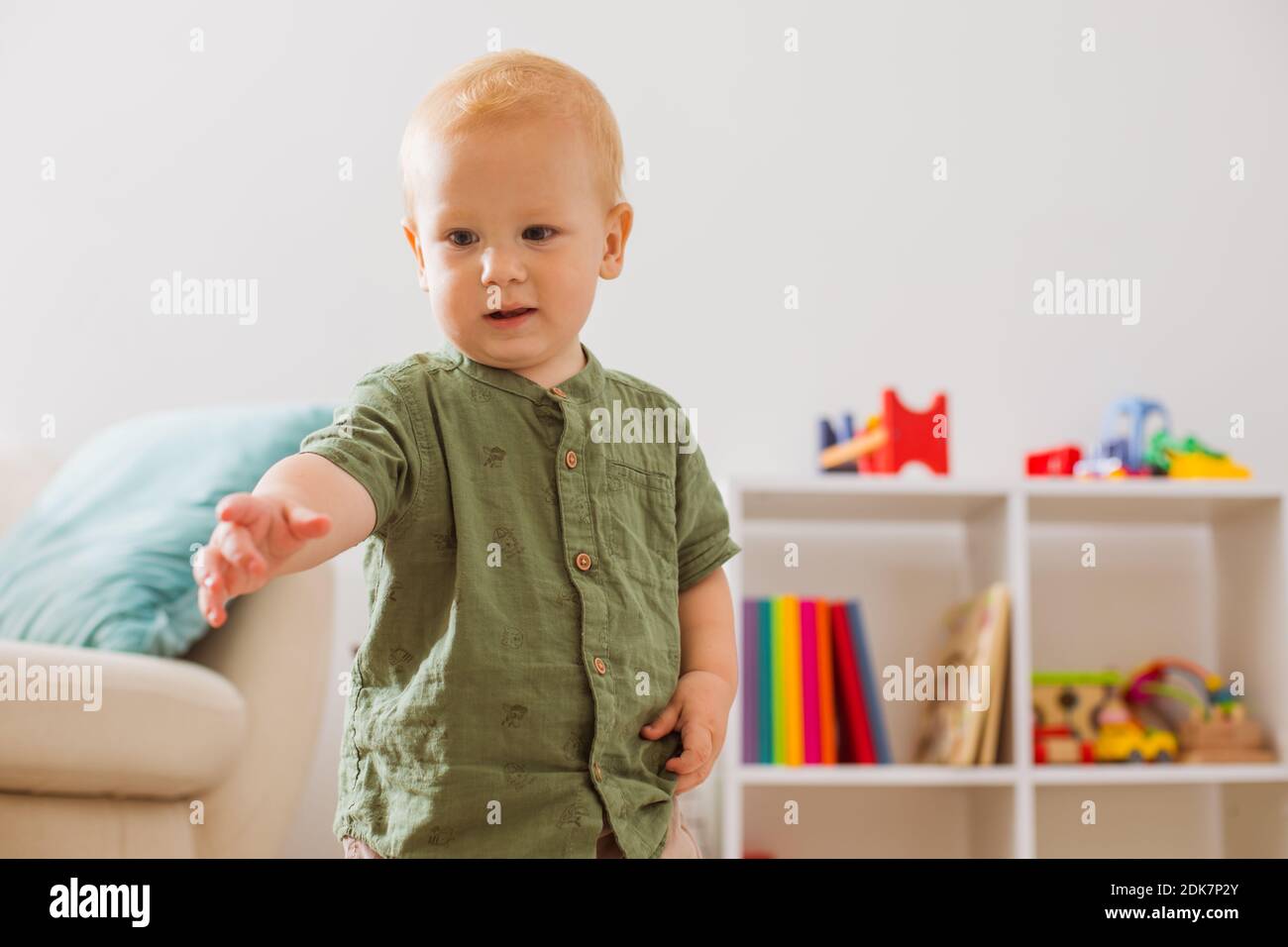 The baby in the playroom is trying to get something Stock Photo - Alamy