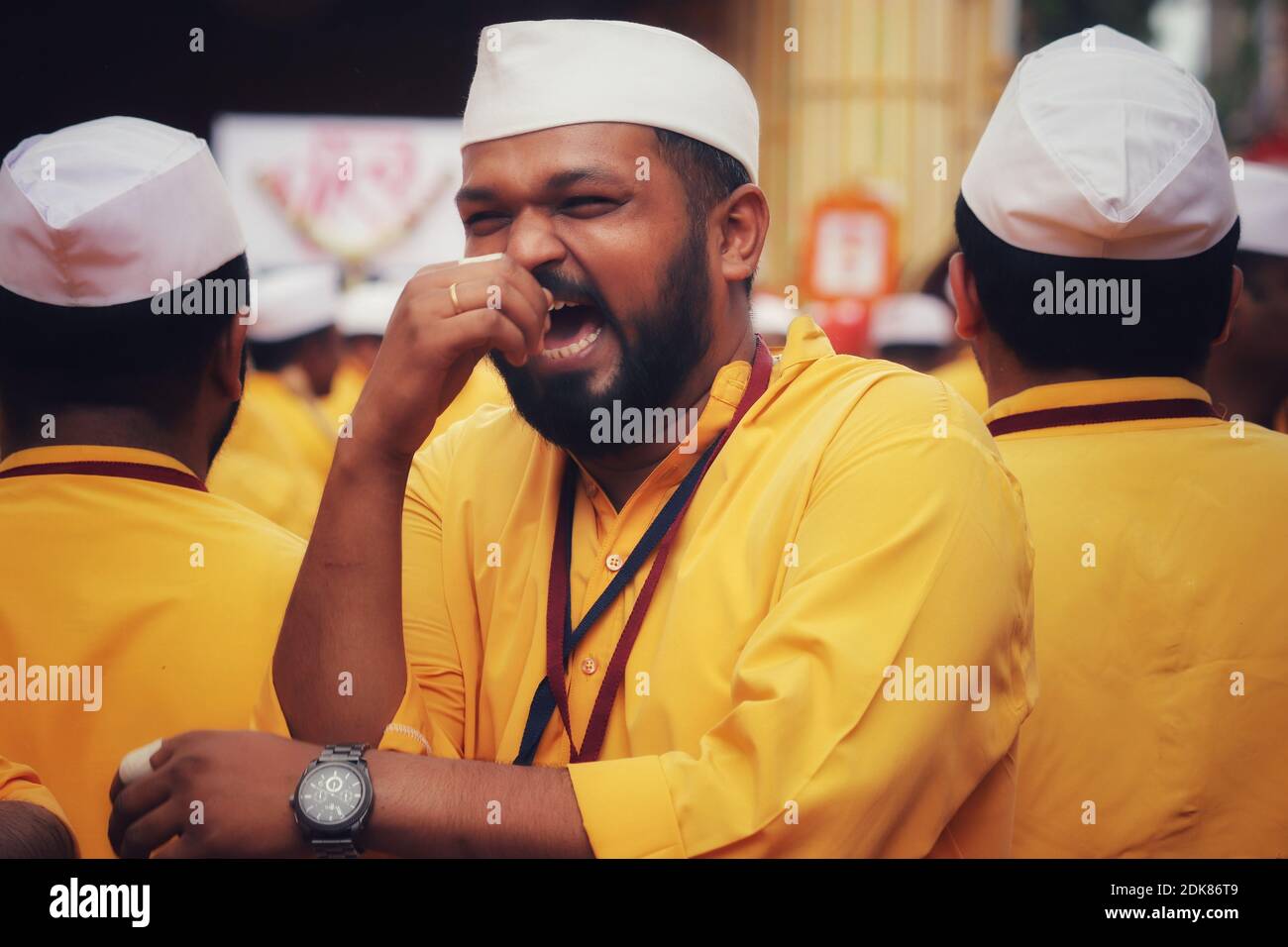 Man Laughing While Standing Behind Friends During Event Stock Photo - Alamy