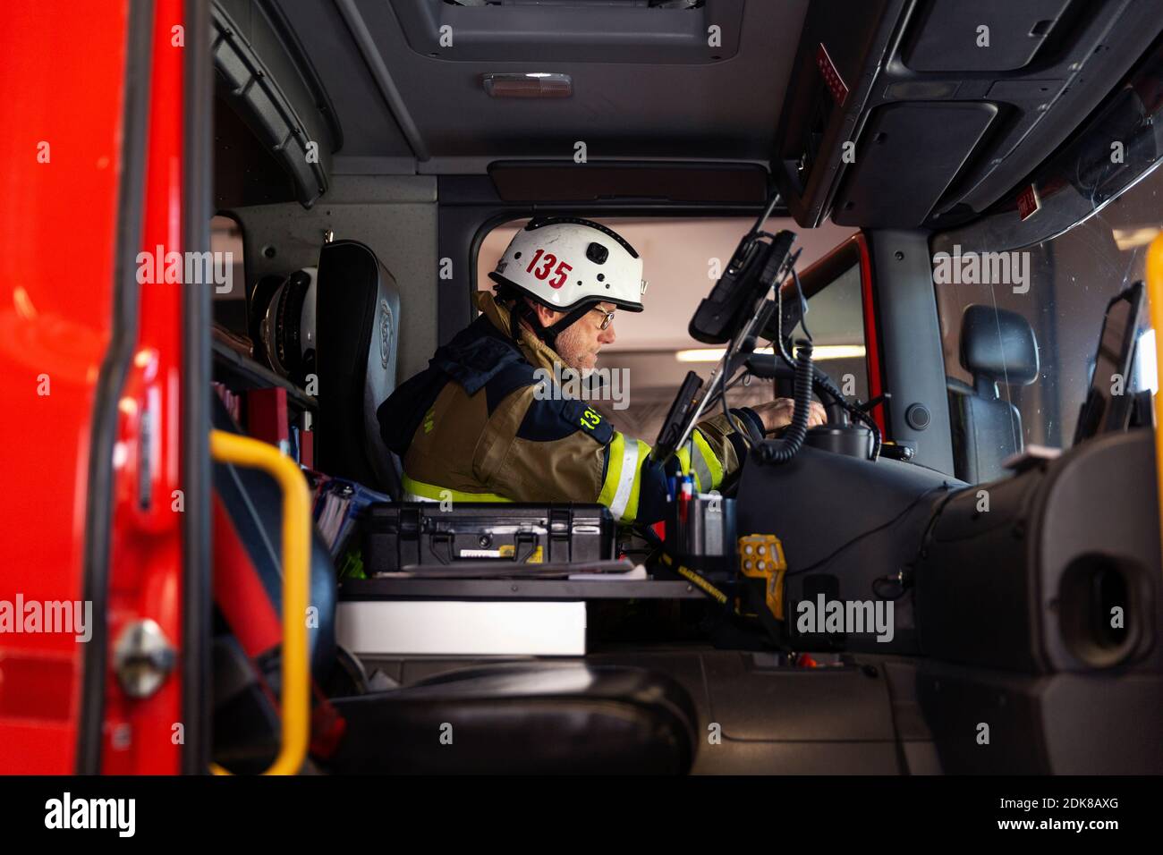 Firefighter in fire engine Stock Photo - Alamy