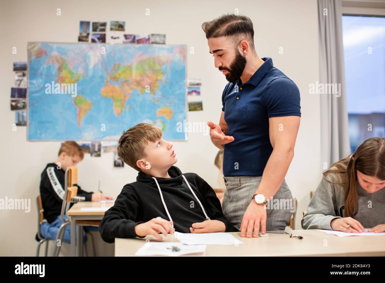 Teacher with schoolboy in classroom Stock Photo - Alamy
