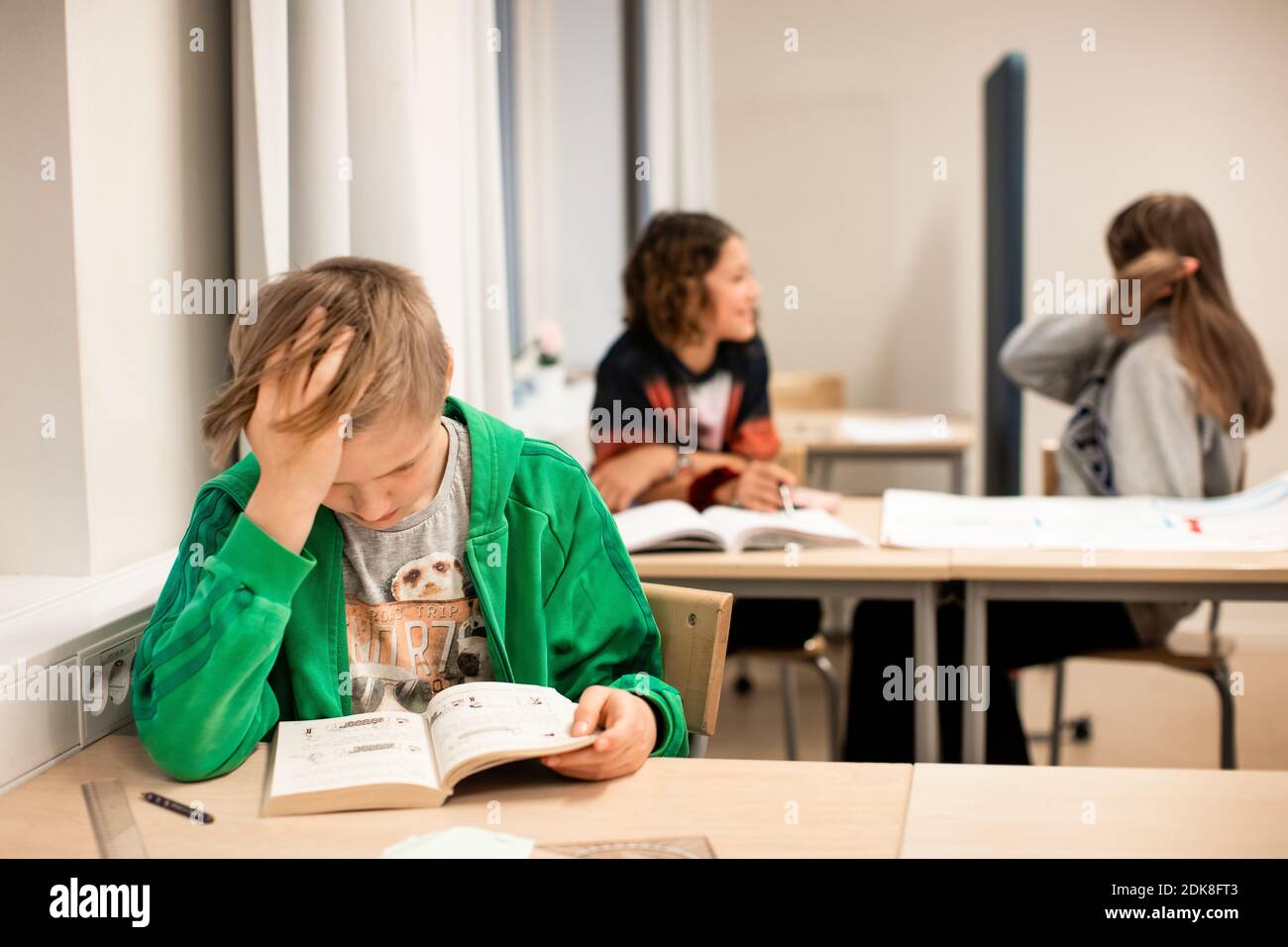 Boy reading in classroom Stock Photo - Alamy
