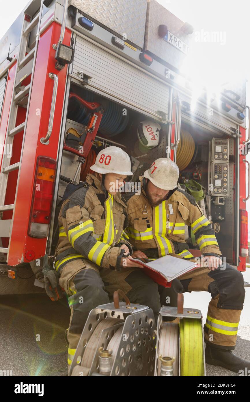 Firefighters studying documents Stock Photo - Alamy
