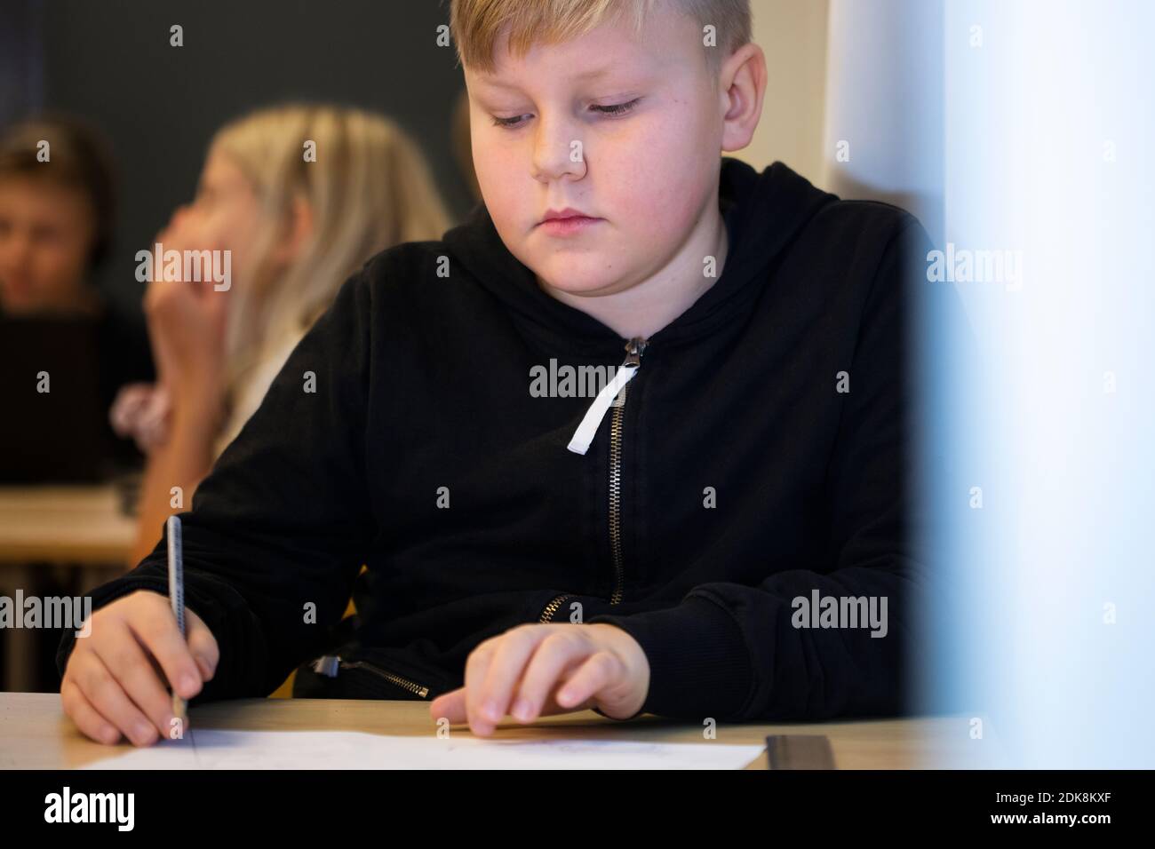 Boy sitting in classroom Stock Photo - Alamy