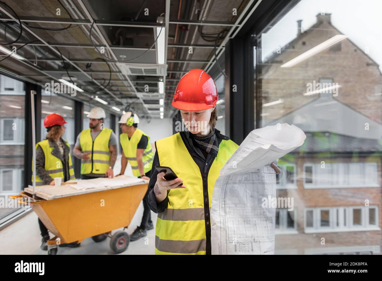 Female construction worker looking at blueprints Stock Photo - Alamy