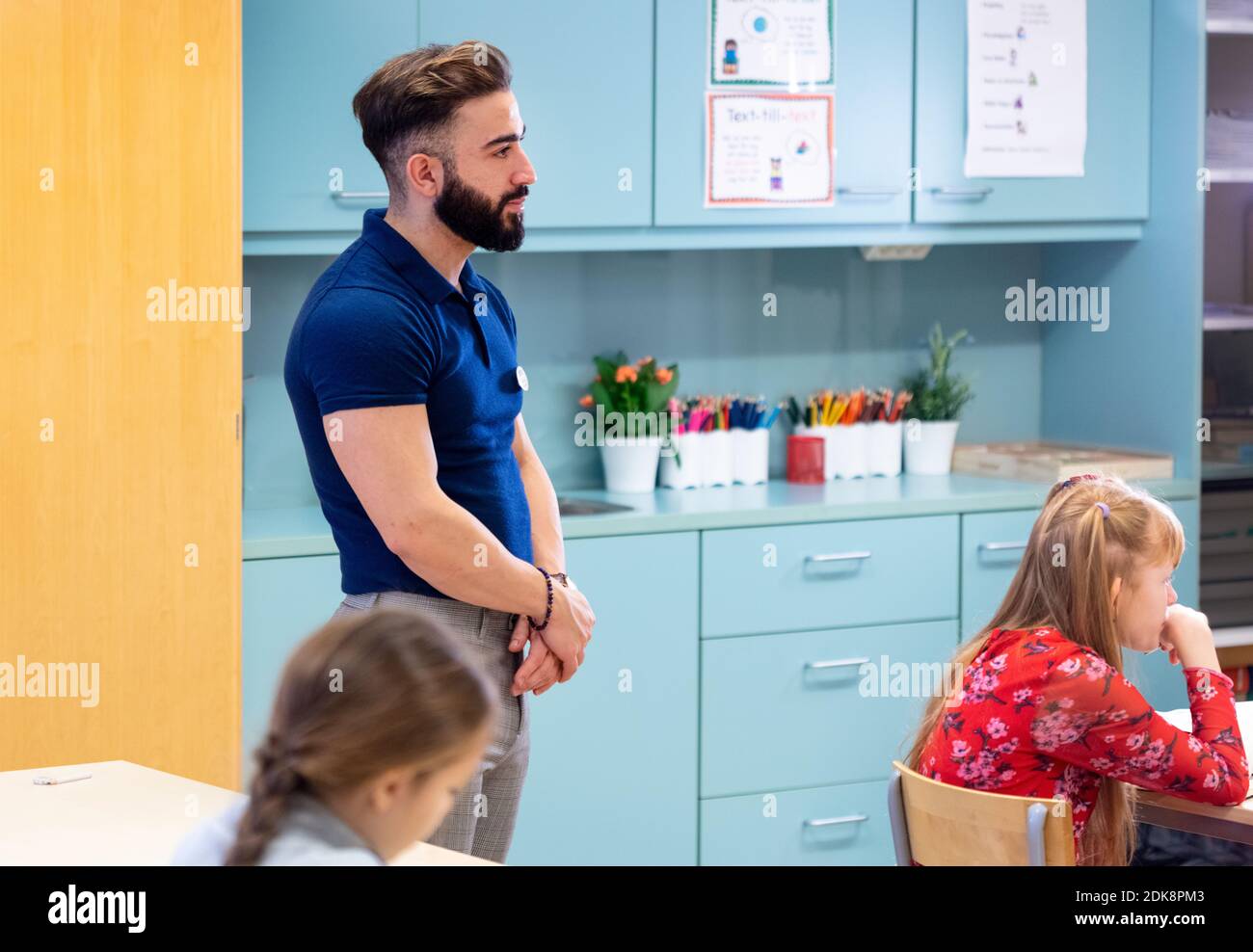Teacher standing in classroom Stock Photo - Alamy