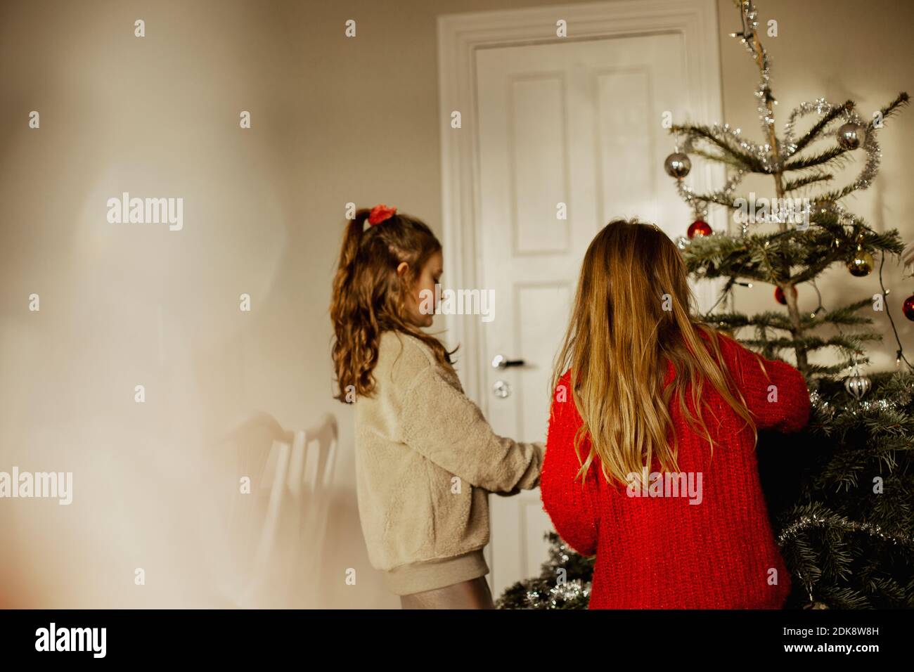 Girls decorating Christmas tree Stock Photo - Alamy