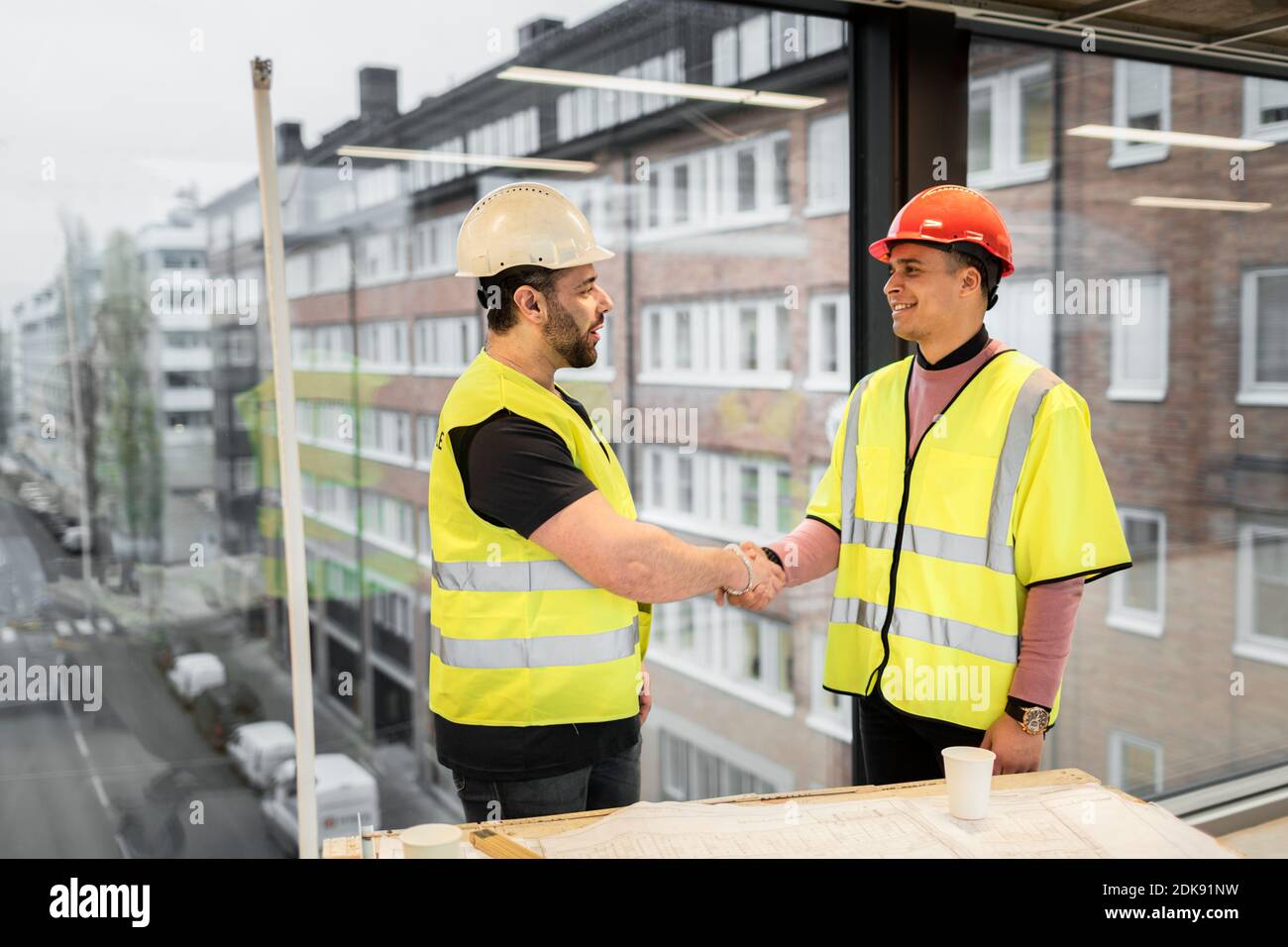 Workers having handshake at construction site Stock Photo - Alamy