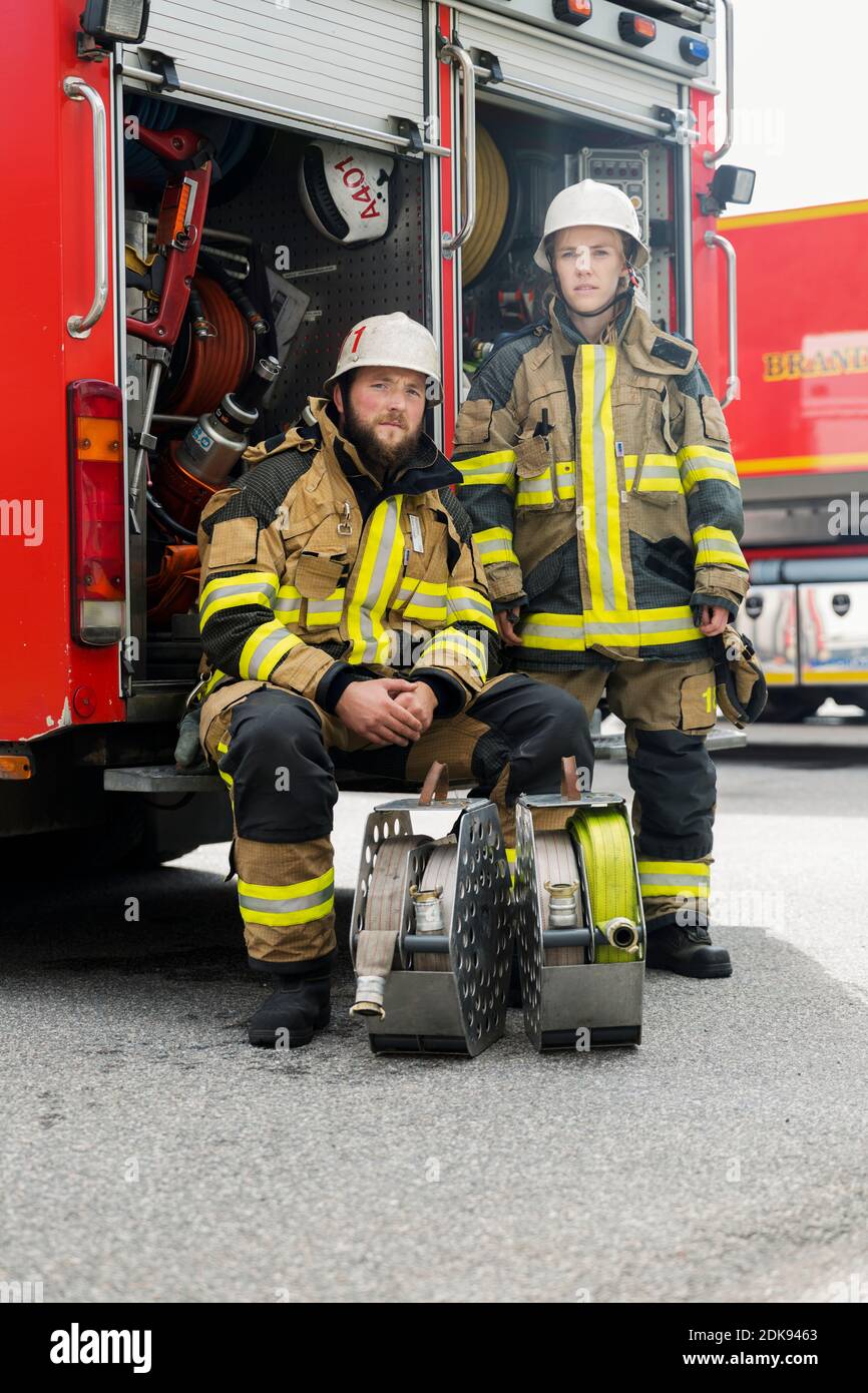 Firefighters in front of fire truck Stock Photo - Alamy