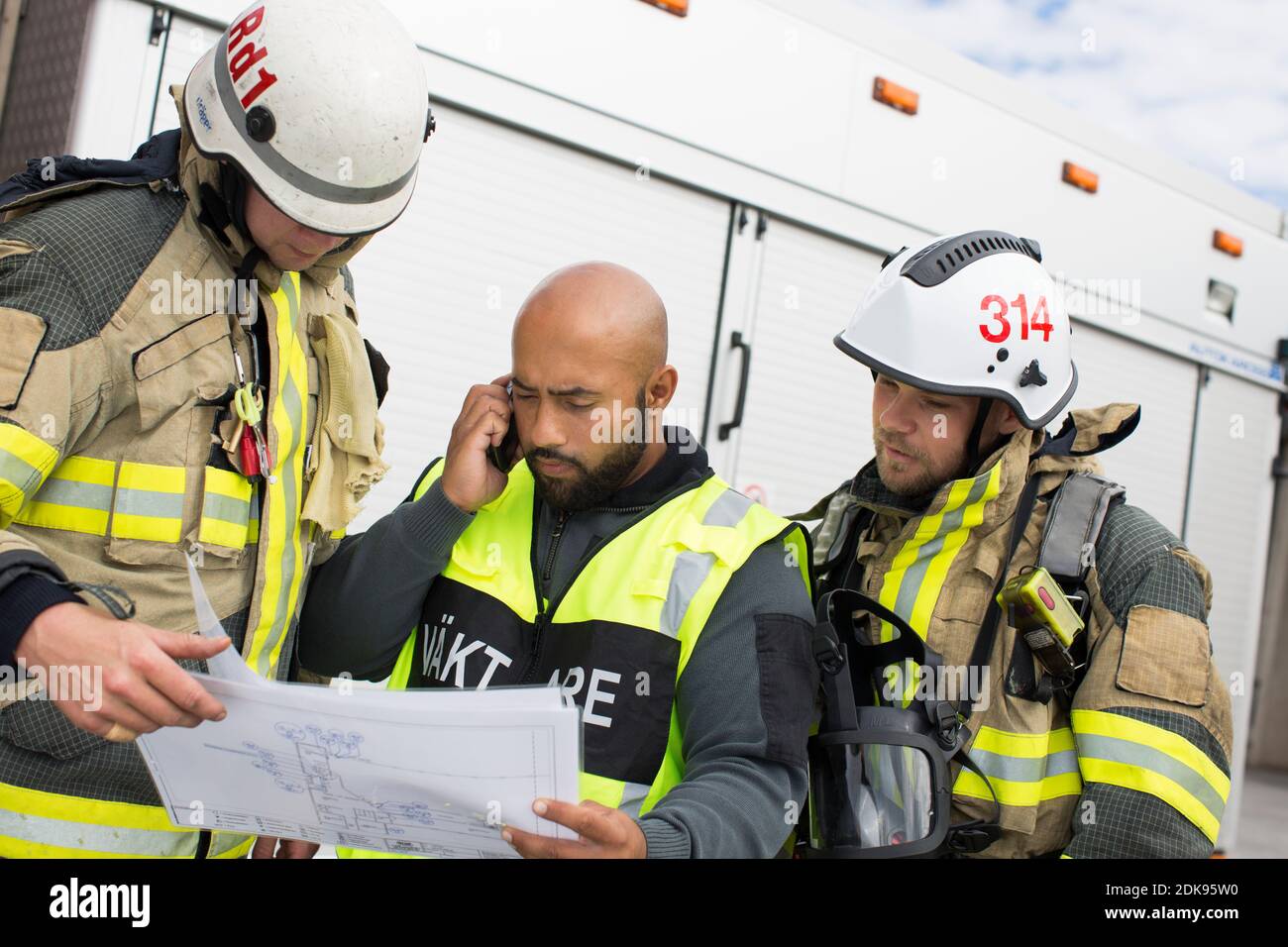 Security guard and firefighters discussing plan Stock Photo - Alamy