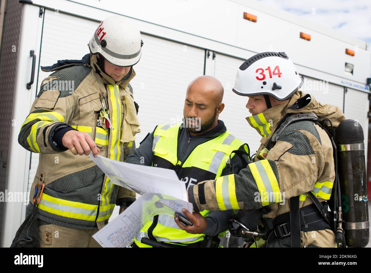 Security guard and firefighters discussing plan Stock Photo - Alamy