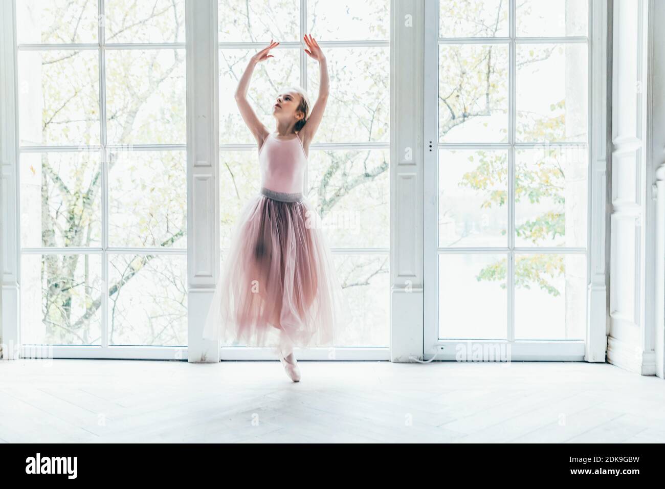 Young classical ballet dancer girl in dance class. Beautiful graceful ballerina practice ballet ...