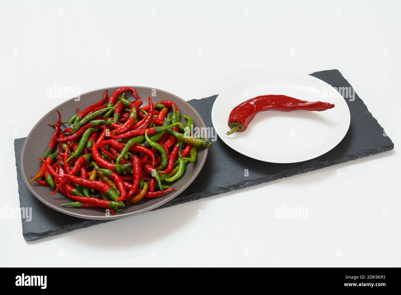 Plates with fresh and dry hot peppers on the stone cutting board Stock ...