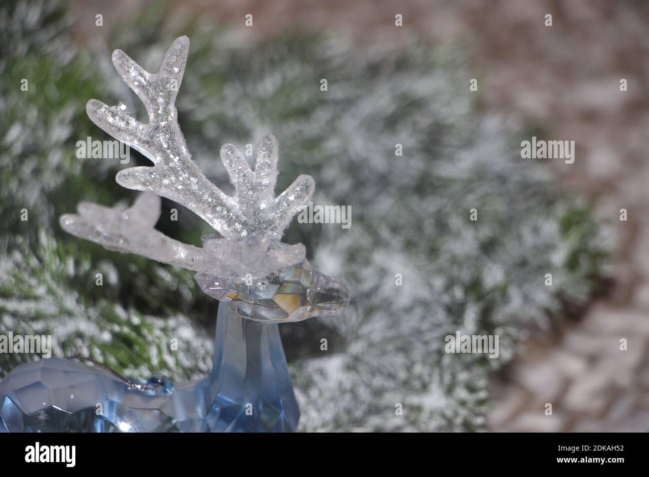 Crystal deer statuette in front of snowy fir. Christmas background ...