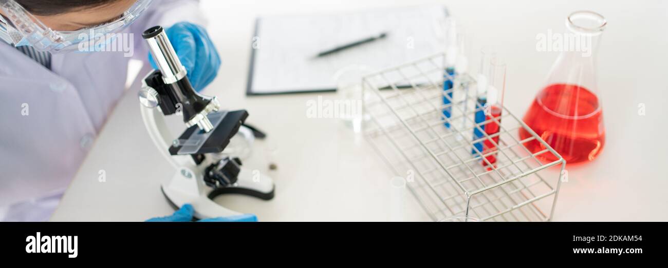 Young Asian scientist Working looking through a microscope doing ...