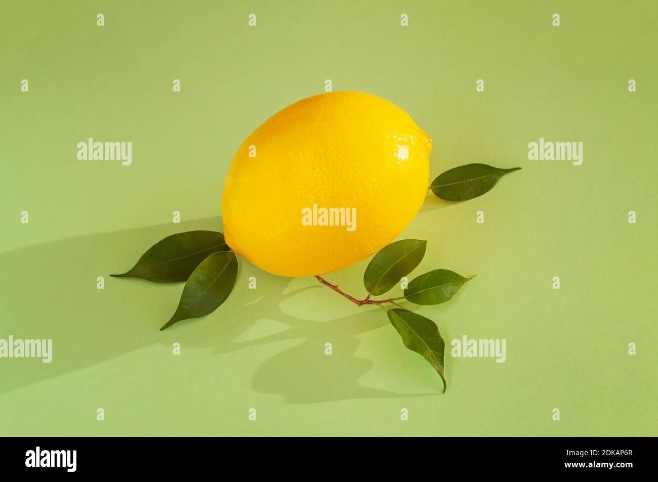 One yellow lemon on tender green background, top view. Fruit minimalism ...