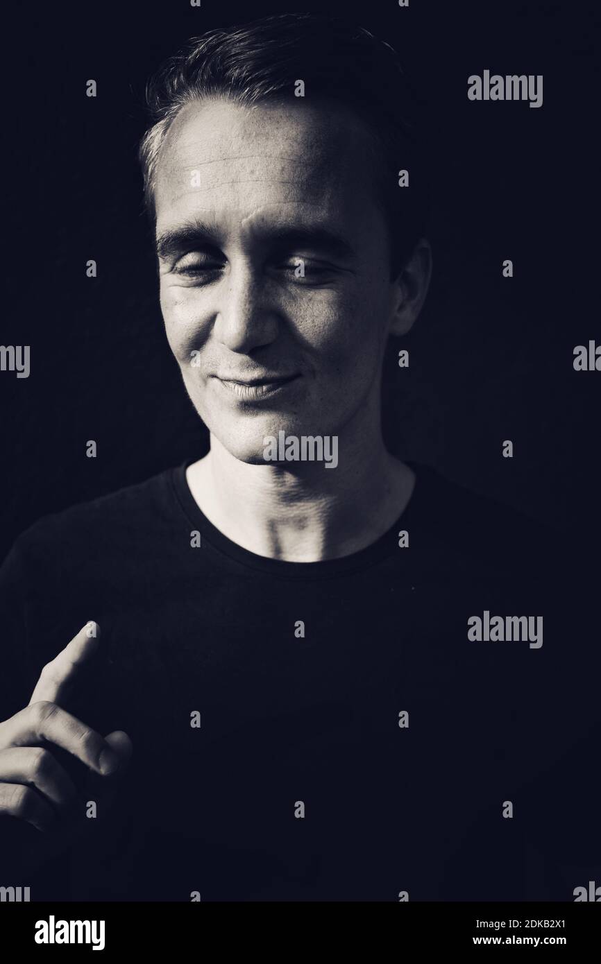 Young Man Holding Up Index Finger Against Black Background Stock Photo ...