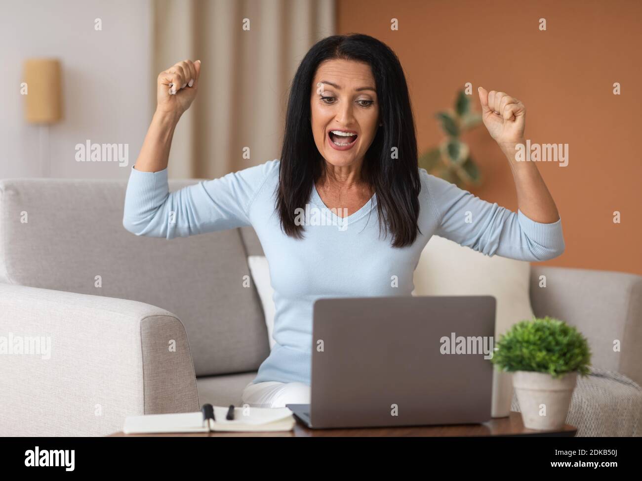 Excited mature woman screaming yes using laptop computer Stock Photo ...