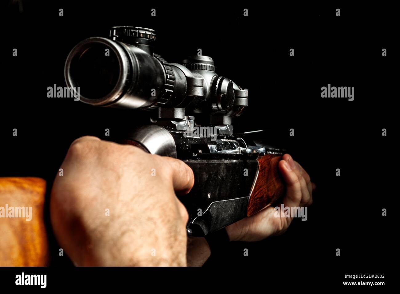 Male hands holding hunting rifle on black background Stock Photo - Alamy