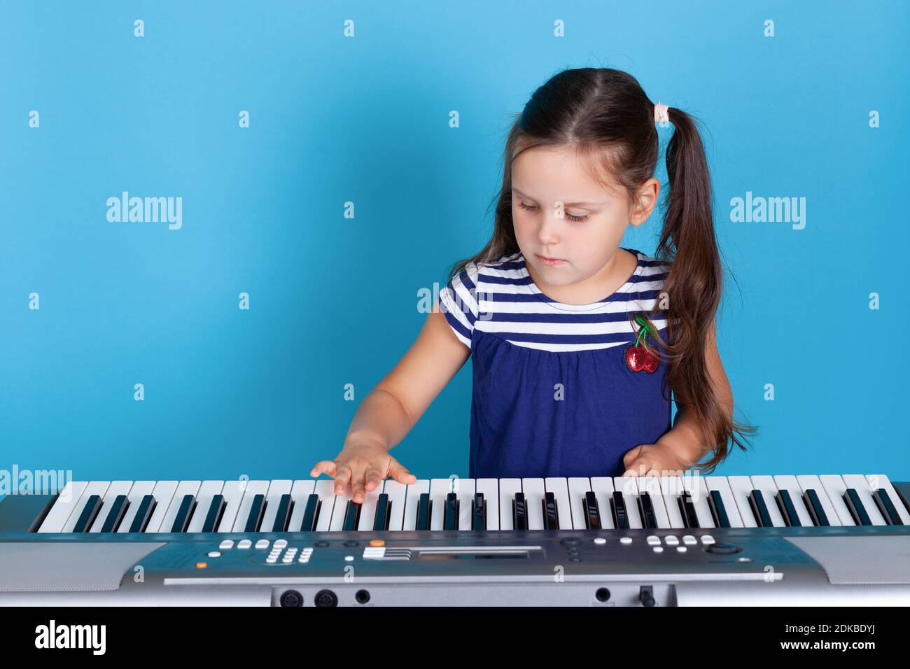 front view close up portrait of a girl enthusiastically playing n piano ...