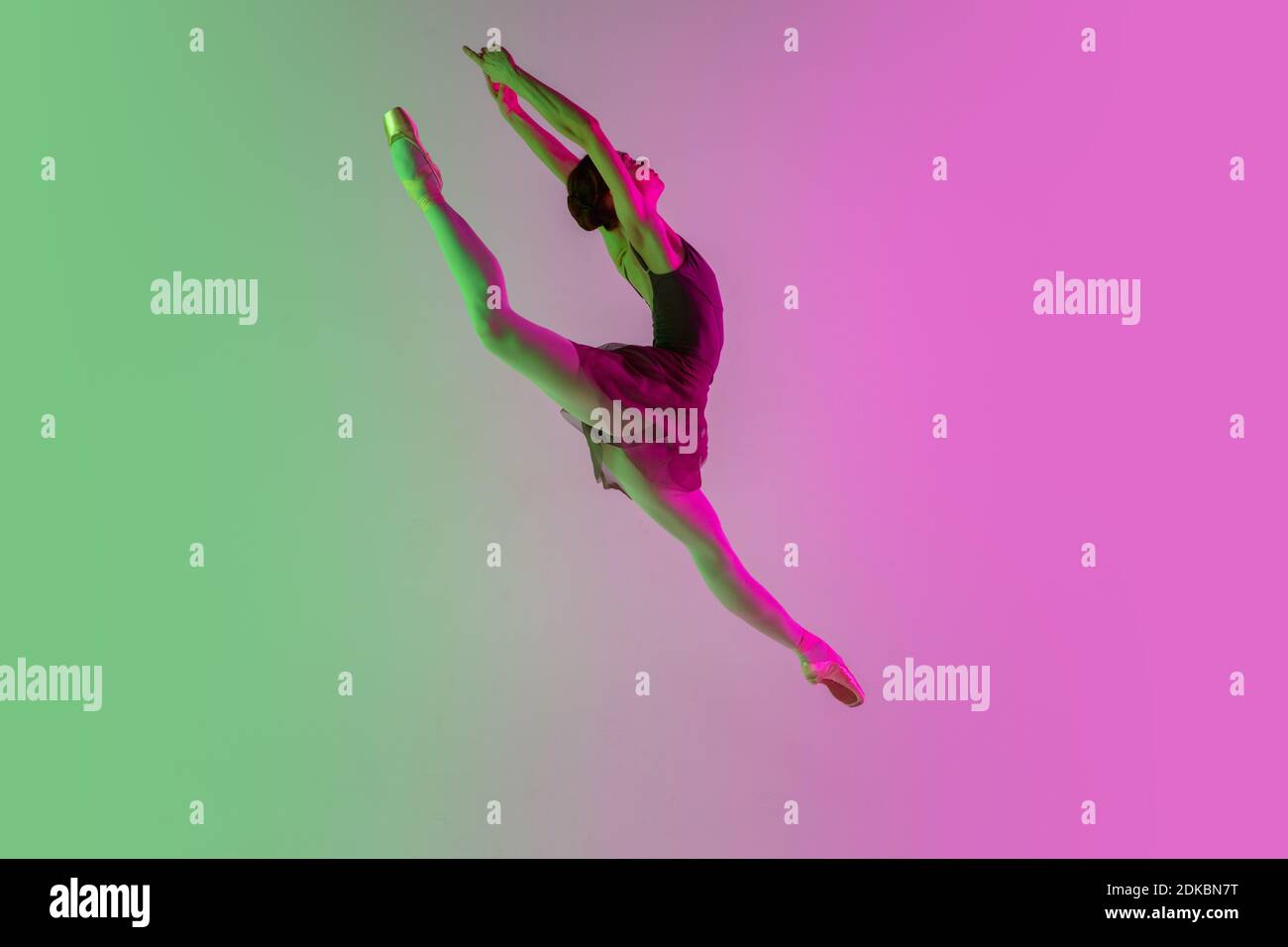 Flying. Young and graceful ballet dancer isolated on gradient pink ...