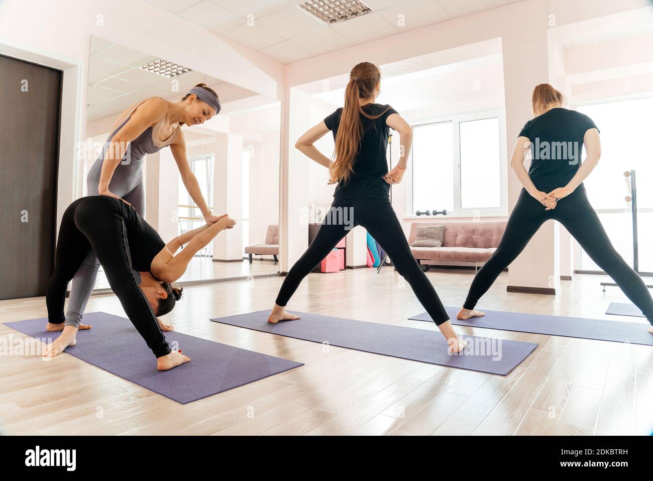 Women Practicing Poses In Yoga Class with trainer Stock Photo - Alamy