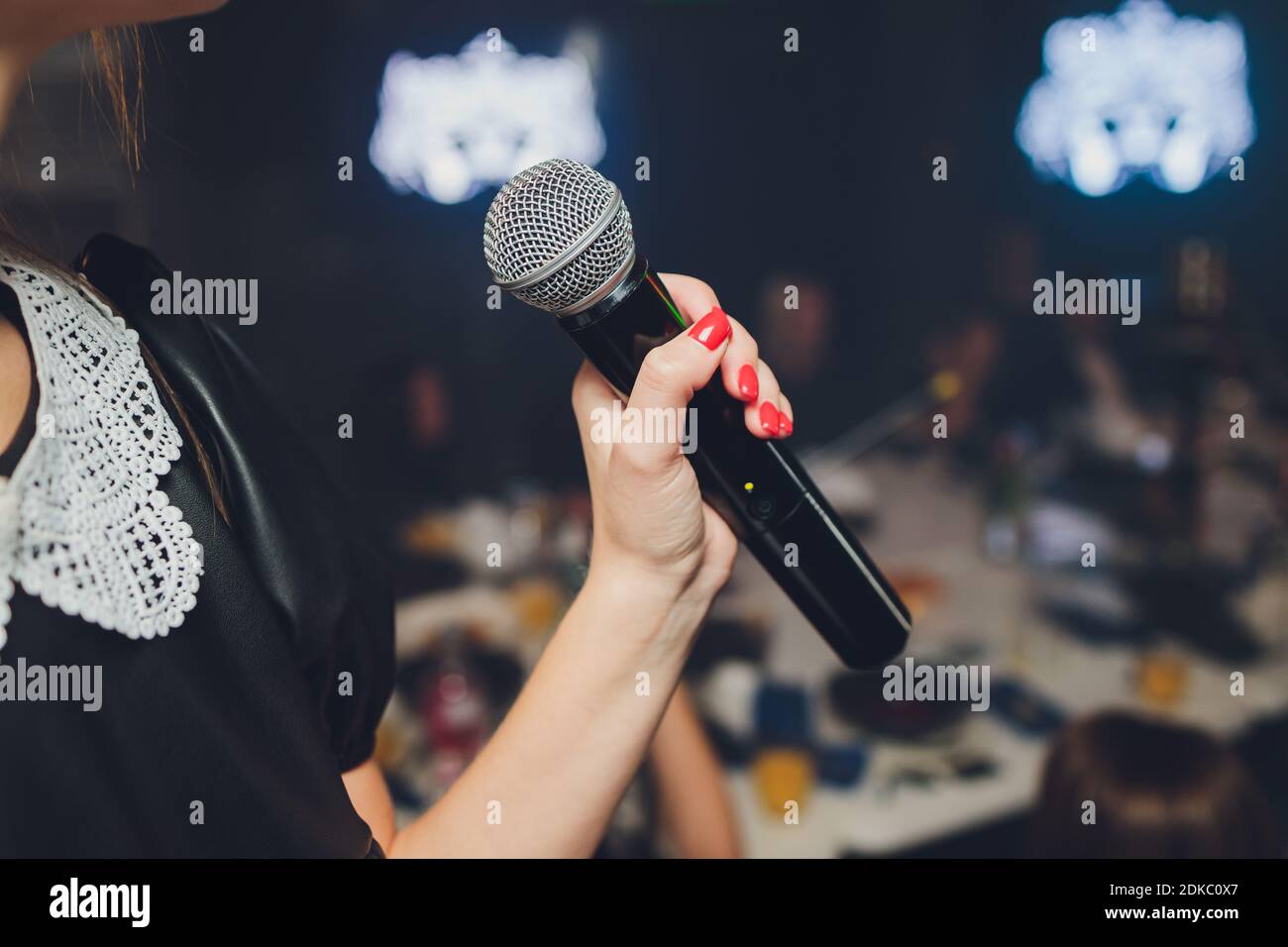 Microphone and unrecognizable female singer close up. Cropped image of ...