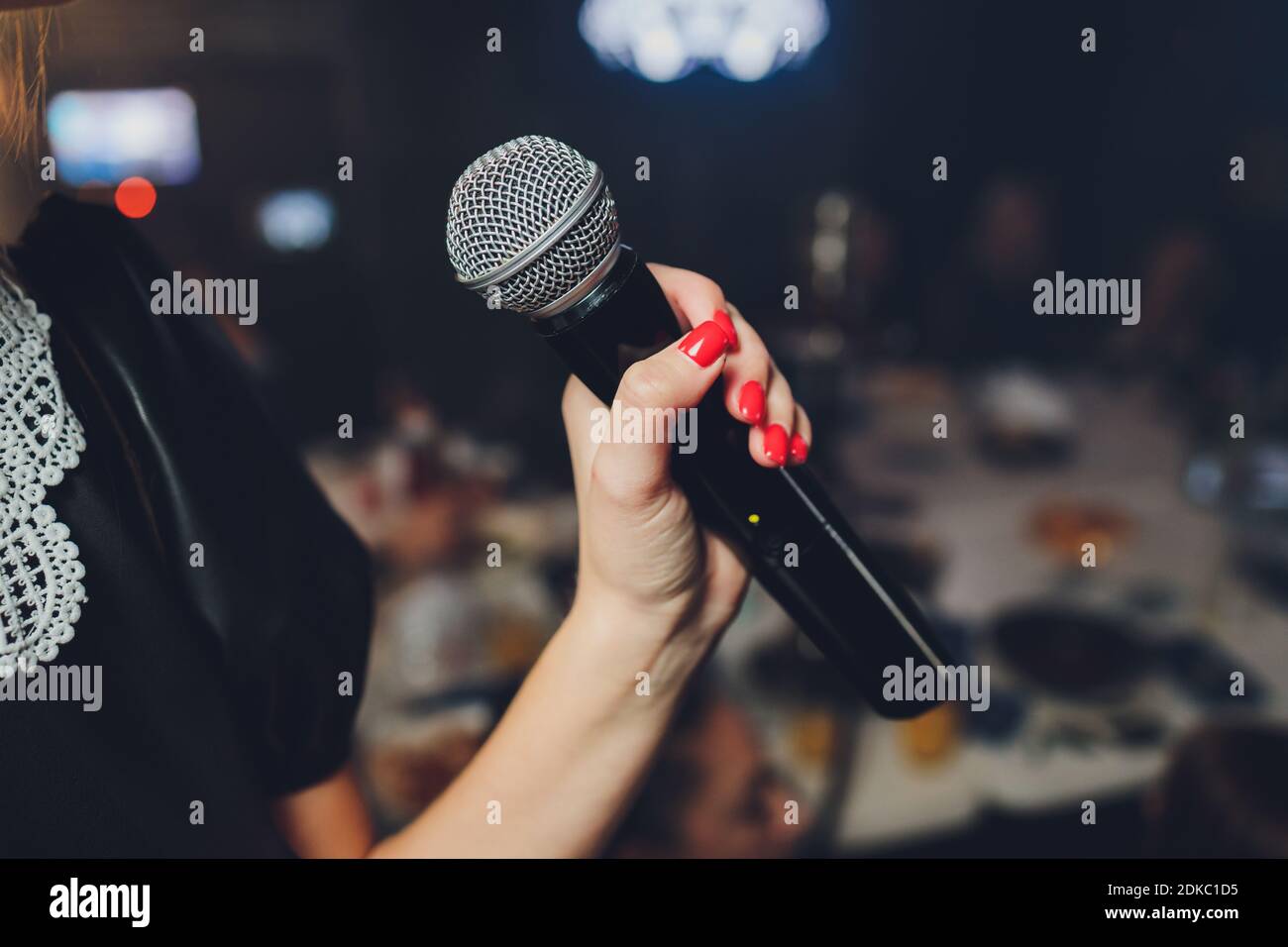 Microphone and unrecognizable female singer close up. Cropped image of ...